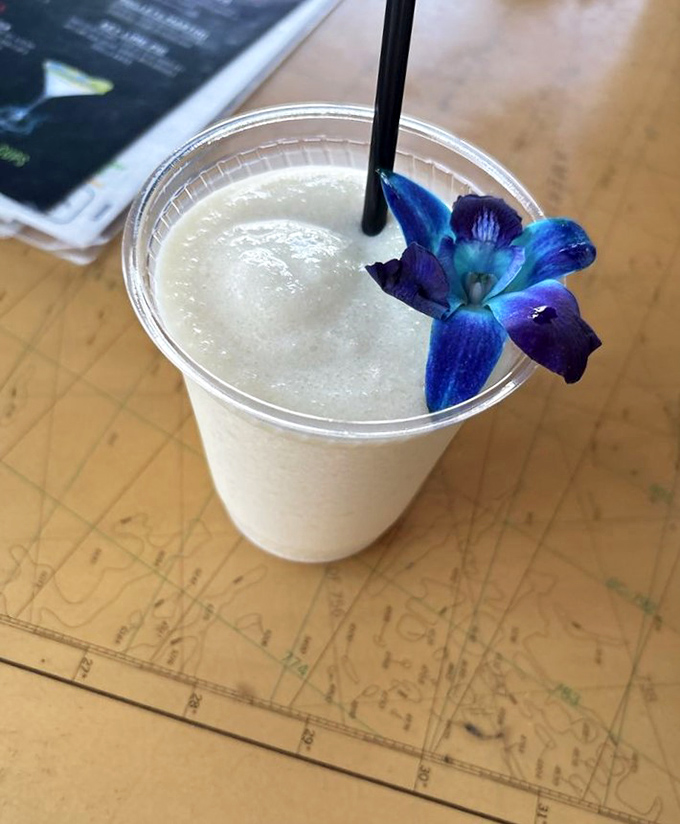 Tropical refreshment: A frosty pi&ntilde;a colada adorned with a vibrant blue orchid &ndash; the perfect companion to seafood and sunshine.