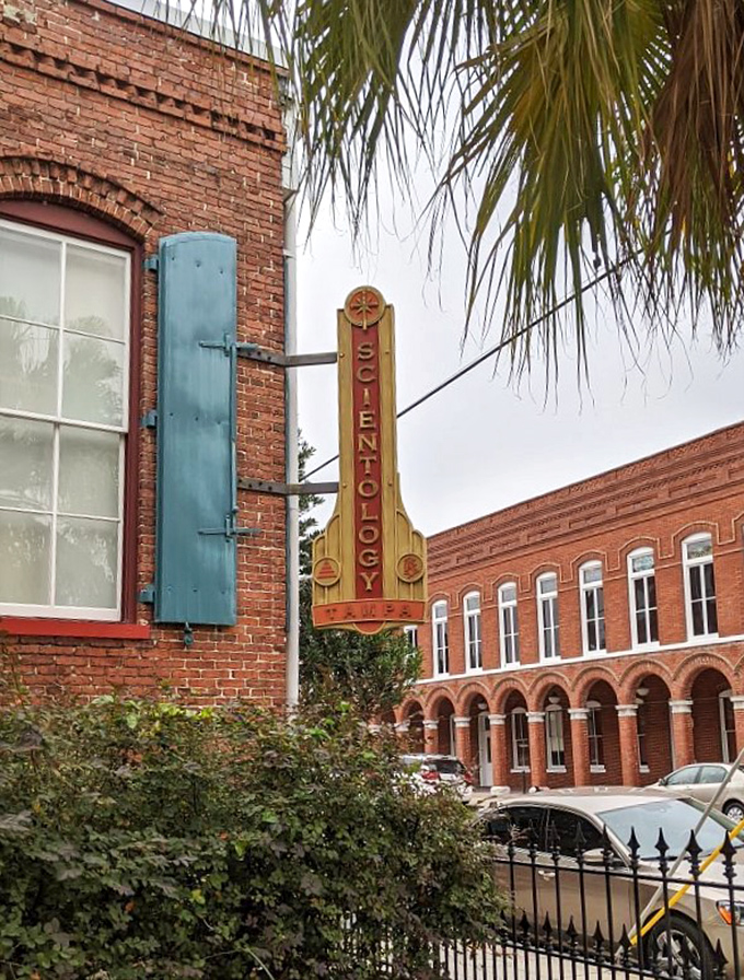 The historic Scientology building's vintage sign stands as a reminder of Ybor's architectural preservation efforts, its art deco details catching the afternoon light.