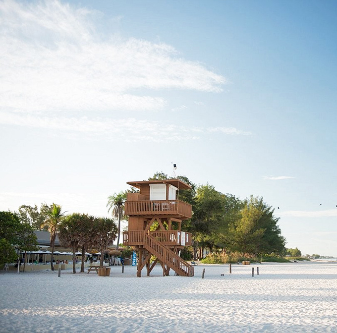 The wooden observation tower stands sentinel over sugar-white sands, offering panoramic views that make smartphone cameras work overtime.