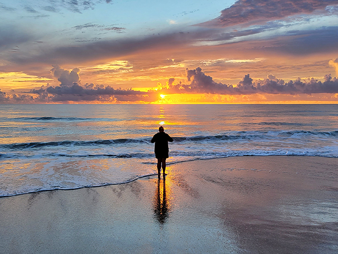 A solitary figure communes with the setting sun, creating the kind of silhouette that makes everyone suddenly fancy themselves photographers.