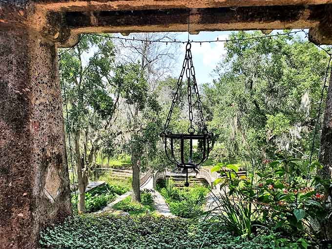 From this shaded vantage point, the property's gardens unfold below like a green tapestry, with stone pathways weaving through what was once a lush paradise.