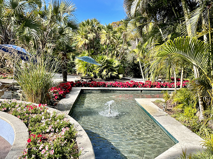 A geometric fountain creates soothing water music, surrounded by a riot of colorful blooms that dance to its liquid rhythm.