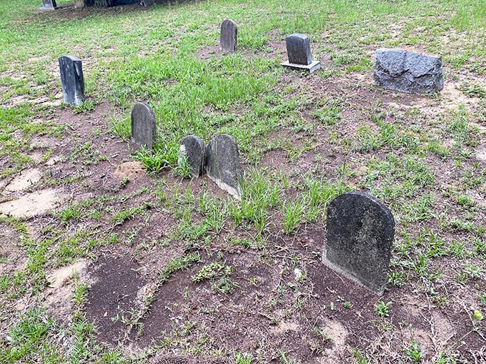 Weather-worn markers lean with age, their fading inscriptions like whispers from the past that grow fainter with each passing year.