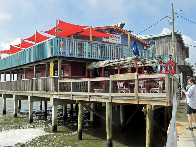 Colorful buildings on stilts reflect in the calm waters of Cedar Key, creating a postcard-perfect scene of Old Florida.