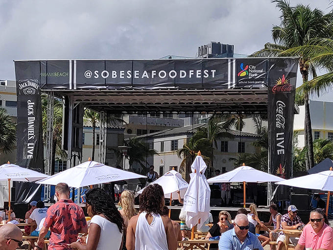 The sleek festival entrance welcomes guests to a beachfront celebration where palm trees sway and gourmet seafood awaits beneath sunny skies.