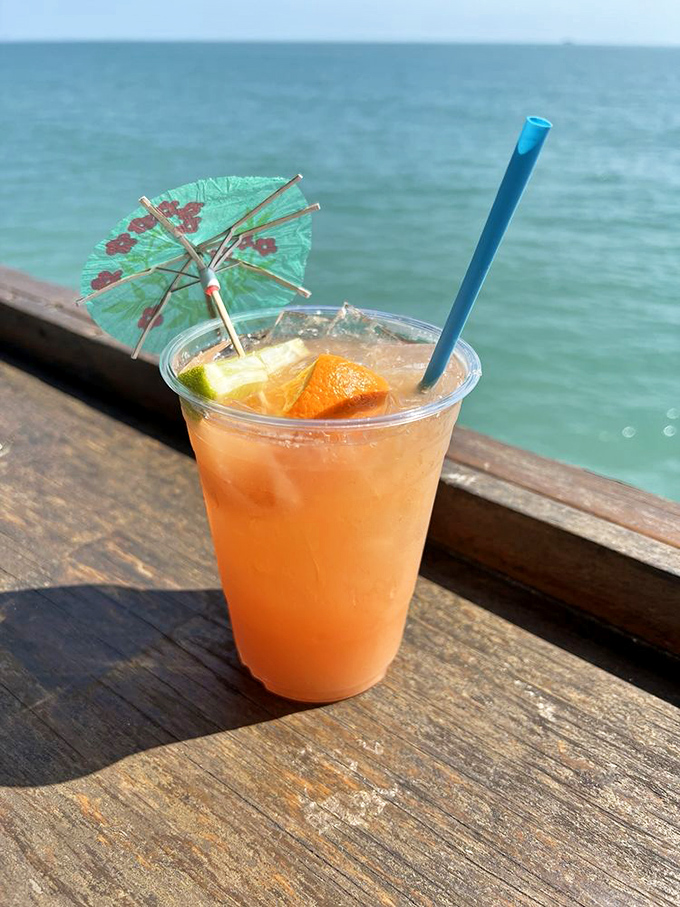 A Bahama Mama cocktail catches afternoon light, its peachy-orange hues matching the relaxed vibe of oceanfront sipping with a tiny umbrella flourish.