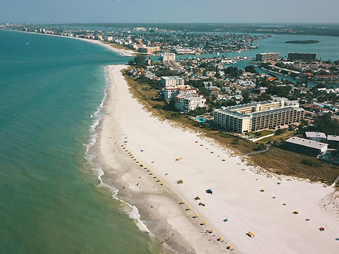 Miles of pristine shoreline stretch into the distance, where white sand meets emerald waters in perfect harmony.