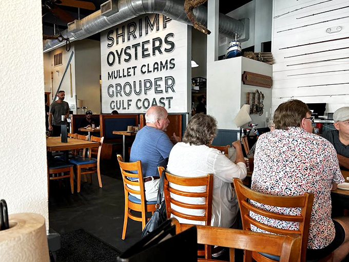 Diners enjoying the authentic maritime atmosphere under that statement seafood sign &ndash; no pretension, just good eating.