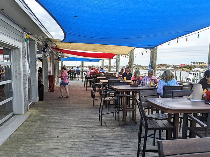 The outdoor deck offers Gulf views and sea breezes, where strangers become friends over shared platters and cold drinks.