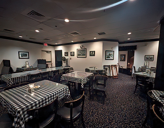 Empty tables draped in classic checkered cloths await the evening rush &ndash; a quiet moment before the symphony of clinking glasses and satisfied sighs.