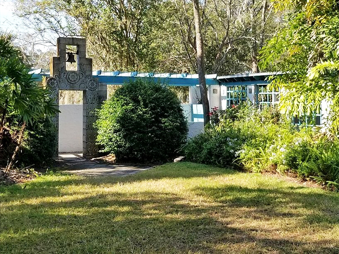 This garden entrance beckons with its simple cross design, standing like a quiet sentinel between the manicured grounds and artistic treasures within.