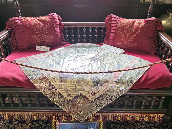 Exquisite craftsmanship transforms this daybed into a royal resting place, where embroidered cushions meet hand-carved wooden details.