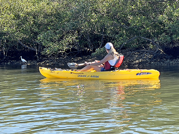 She paddles through the lagoon, each stroke sending ripples of living light dancing across the water.
