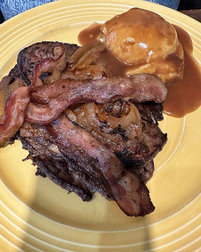 Liver and onions with bacon – a dish that separates the culinary adventurers from the tourists, caramelized to perfection for the true believers.