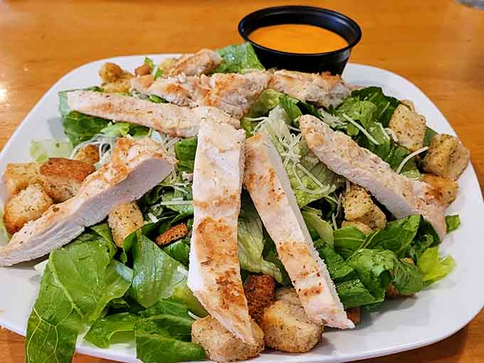 The Caesar salad comes loaded with grilled chicken, offering a lighter option that doesn't skimp on flavor or portion.