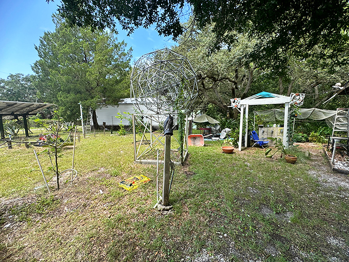 The grounds surrounding the bottle house feature geometric metal sculptures and garden spaces, extending the artistic vision beyond the main structures.