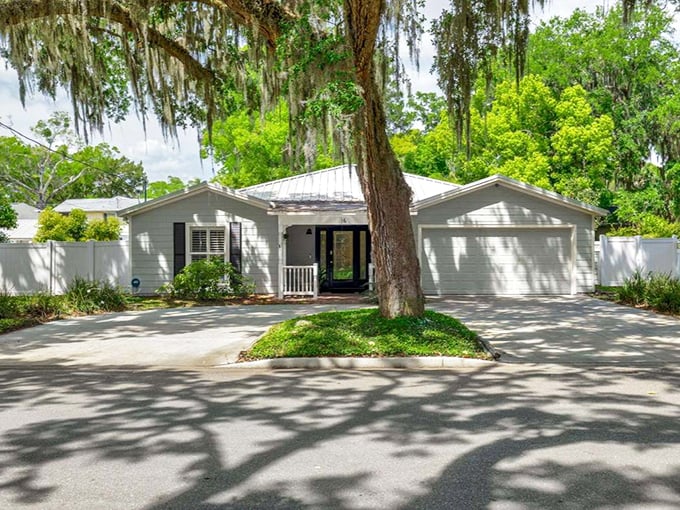 A charming residence finds perfect framing beneath a massive oak, the tree serving as both protector and natural enhancement.