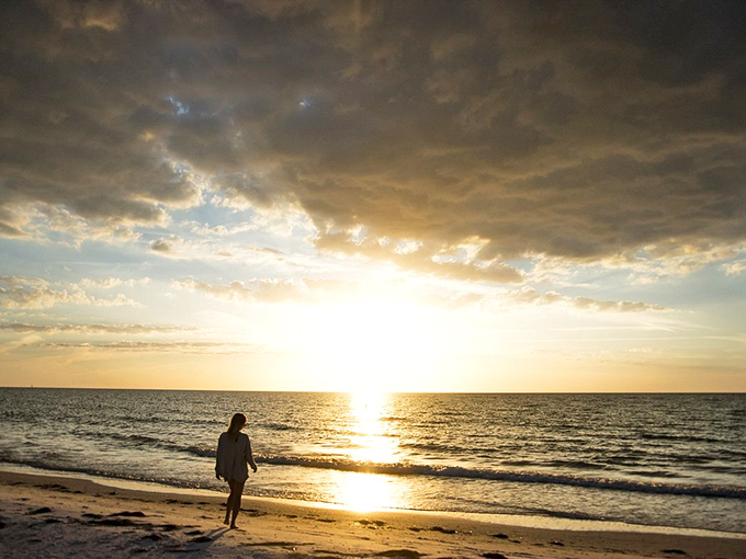 Solitude meets sunset on Anna Maria Island, where even the clouds seem to pause their journey to admire nature's nightly light show.
