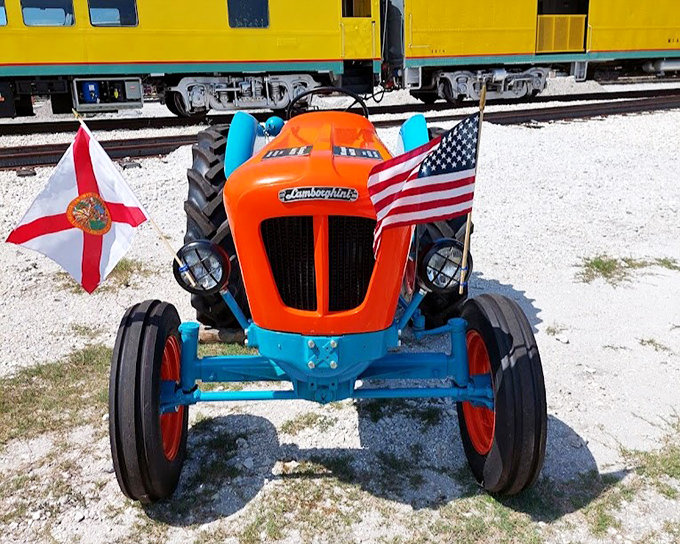 This cheerful Lamborghini tractor sporting Florida's flag provides a colorful contrast to the vintage train's classic lines.