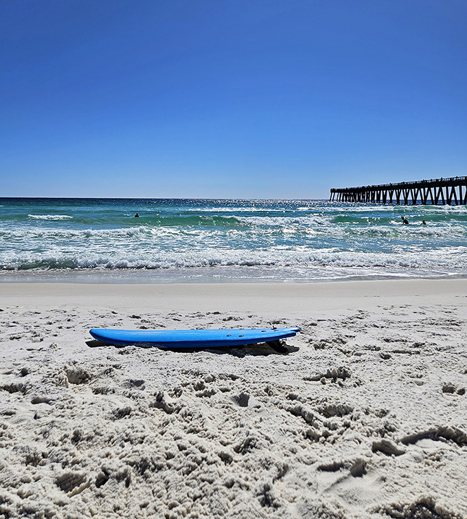 Surfers and paddleboarders find their rhythm beneath the pier's watchful gaze.