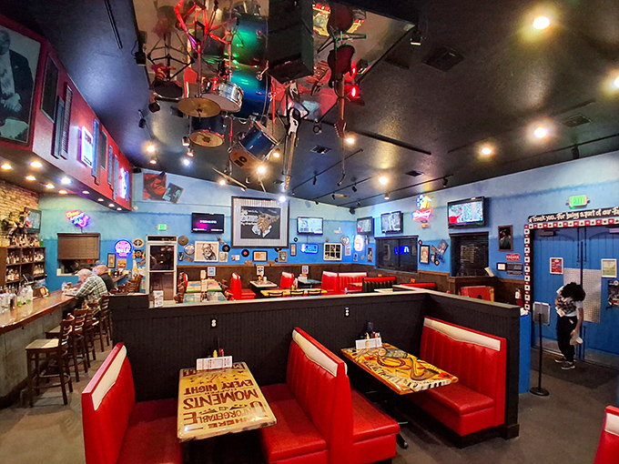 Red booths pop against blue walls in this musical haven where every meal feels like a VIP experience at your favorite concert.