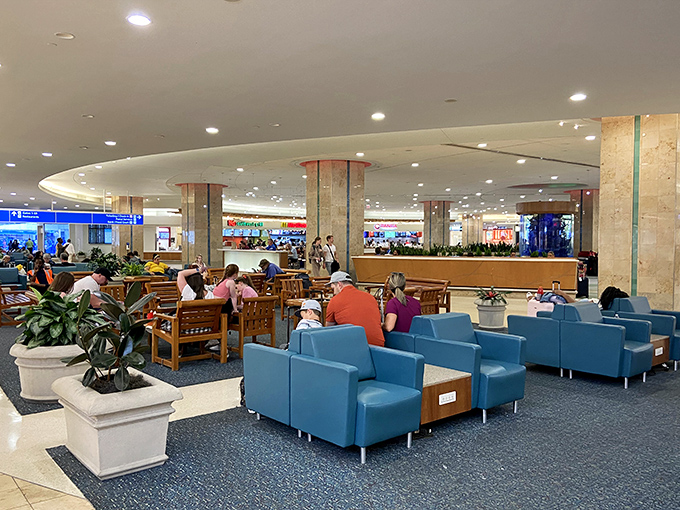 The food court bustles with hungry travelers while our bronze friend maintains his decades-long fast with impressive dedication.