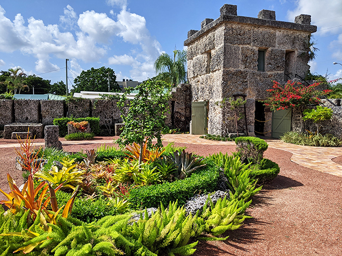 Lush tropical plants now embrace the stone structures, nature's soft touch contrasting with the imposing permanence of Ed's creation.