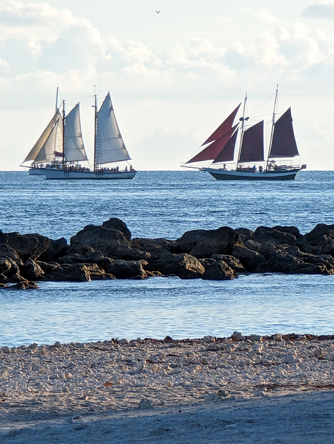 Twin schooners glide across the horizon like time travelers from an era when sailing was the only way to reach this island paradise.