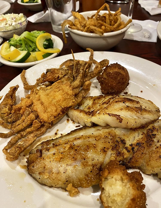 A seafood feast fit for royalty: crispy soft-shell crab, flaky white fish, and golden hush puppies share the spotlight on this generously portioned plate.
