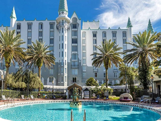 The Castle Hotel's fairy-tale exterior features a striking white fa&ccedil;ade with turrets and spires, offering a royal retreat in the heart of Orlando.