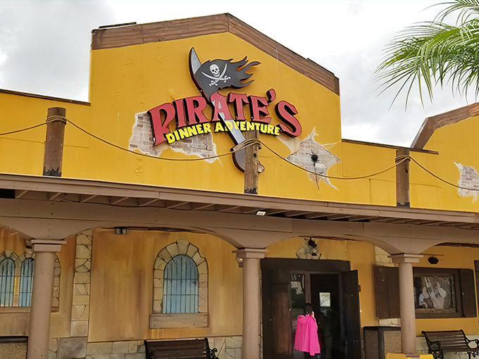 The vibrant yellow exterior of Pirates Dinner Adventure beckons adventure-seekers with its weathered charm and promise of high-seas hijinks.