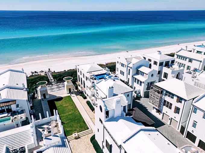 Pristine white buildings rise like Mediterranean dreams against Florida's blue sky, creating Alys Beach's signature postcard-perfect aesthetic.