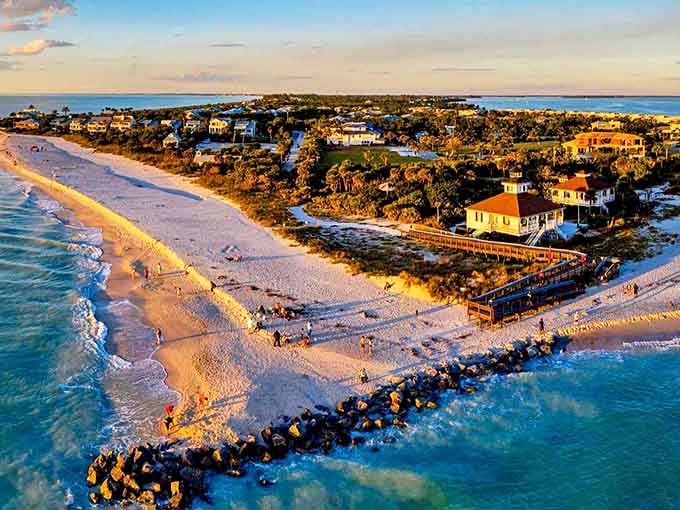 Paradise from above: Boca Grande's pristine shoreline stretches like nature's welcome mat, where turquoise waters meet powdery white sand under the golden Florida sun.