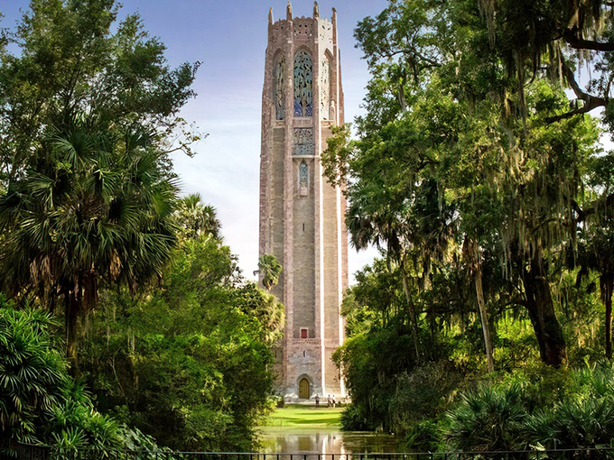 The majestic Singing Tower rises like a medieval sentinel among Florida palms, its pink marble glowing in the sunshine.