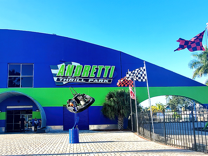 The vibrant blue and green facade of Andretti Thrill Park stands out against the Florida sky, promising high-octane adventures within.