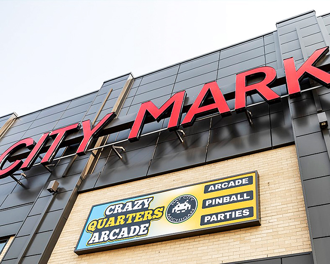 The glowing red City Market sign stands proudly above Crazy Quarters Arcade, a beacon of joy for gamers seeking nostalgic thrills in Michigan.