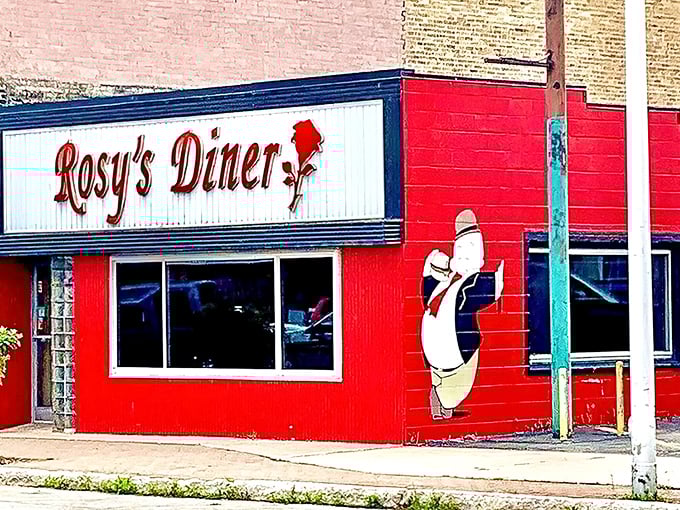 The fire-engine red exterior of Rosy's Diner stands out like a culinary lighthouse on Escanaba's Ludington Street, promising homestyle comfort within.
