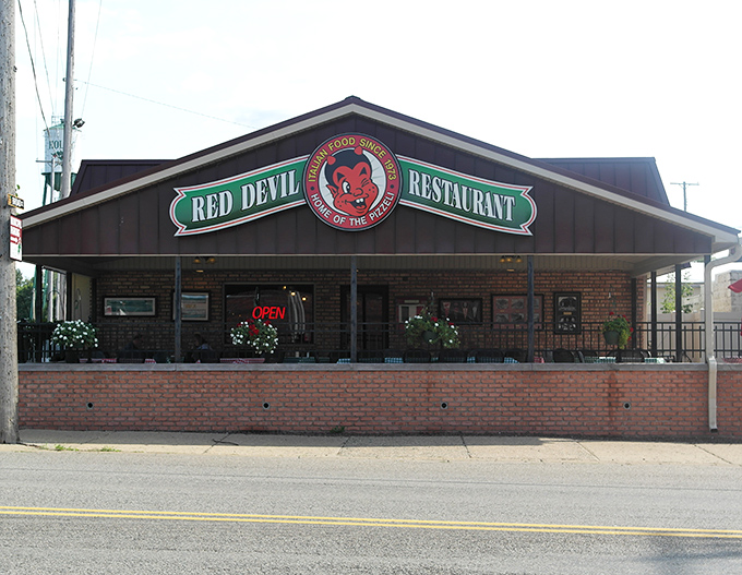 The Red Devil Restaurant's exterior beckons with its charming brick facade and iconic sign &ndash; a humble home for extraordinary Italian cuisine.