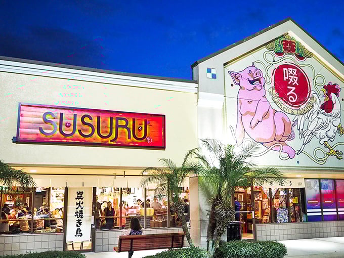 Susuru's vibrant fa&ccedil;ade beckons with a playful pink pig mural &ndash; a neon-lit promise of the whimsy waiting inside.