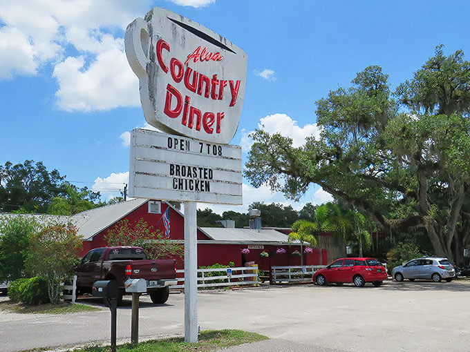 The iconic red exterior of Alva Country Diner stands like a beacon for hungry travelers, promising comfort food that'll make your belt beg for mercy.