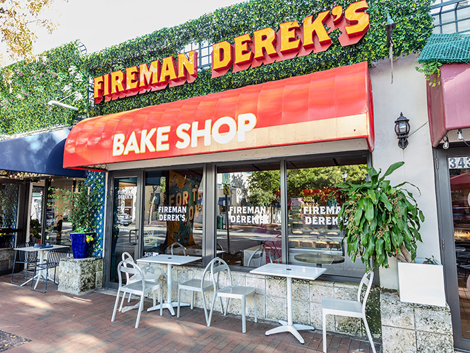 The iconic red awning of Fireman Derek's Bake Shop stands out against the lush greenery of Coconut Grove, promising sweet treasures within.