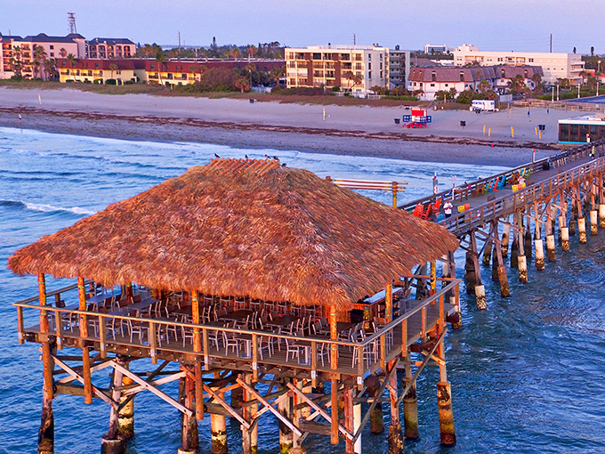 Sunset transforms Rikki Tiki Tavern into a postcard-perfect vision, where thatched roofs and ocean waves create Florida's most enviable happy hour spot.