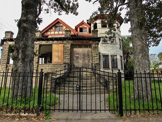 The grand entrance beckons with mysterious charm, its stone steps and boarded windows hinting at forgotten elegance beneath Jacksonville's swaying palms.