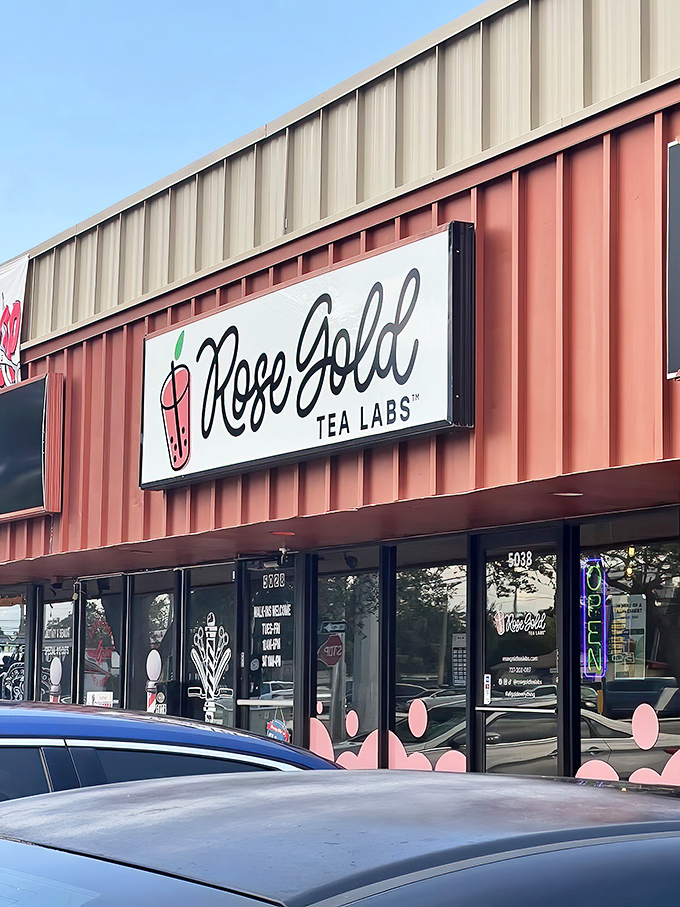 The coral-colored exterior of Rose Gold Tea Labs promises sweet surprises inside, standing out like a dessert oasis in the strip mall landscape.