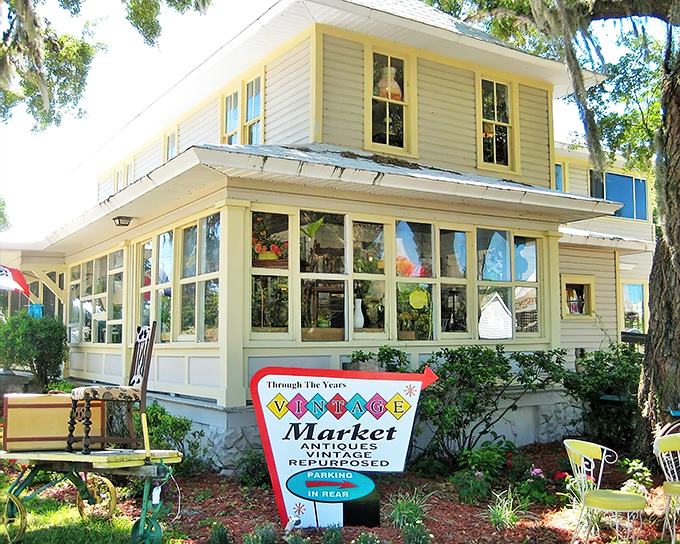 The cheerful yellow exterior of Through The Years Vintage Market welcomes treasure hunters with its wraparound porch and vintage charm.