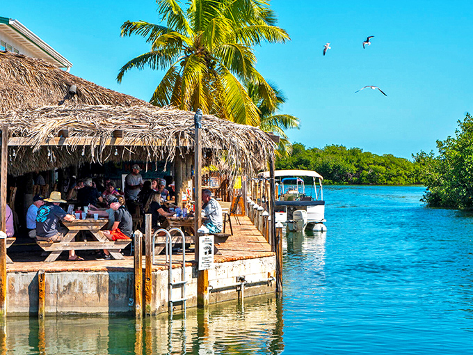 Waterfront bliss at Geiger Key Marina Fish Camp Restaurant, where turquoise waters meet thatched roofs and time slows to the rhythm of gentle waves.