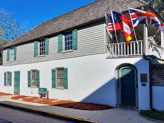 The Gonz&aacute;lez-&Aacute;lvarez House stands proudly with its colonial charm and mint-green shutters, flags fluttering above like colorful sentinels guarding America's oldest home.