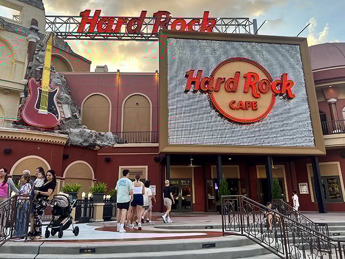 The iconic Hard Rock Cafe Orlando facade glows with rock 'n' roll promise against the twilight sky, beckoning music lovers and foodies alike.