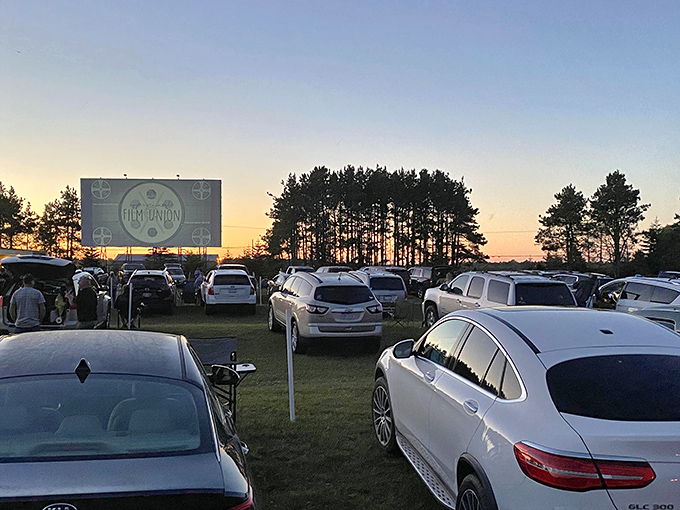 Twilight magic at Highway 2 Drive-In, where cars gather like fireflies beneath the massive screen awaiting dusk's cinematic transformation.