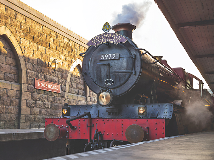 The legendary Hogwarts Express steams into Hogsmeade Station, its iconic 5972 number gleaming against the black and crimson paintwork.